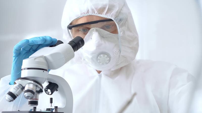 Scientist in Ppe Analyzing Samples Using a Microscope in a Laboratory ...