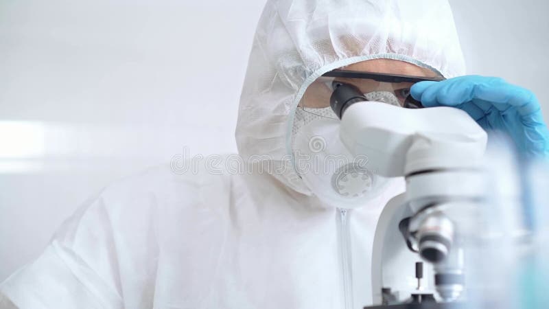 Scientist in Ppe Analyzing Samples Using a Microscope in a Laboratory ...