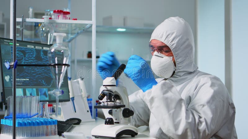 Scientist in Ppe Suit Placing a Slide on Specimen Stage Stock Footage ...