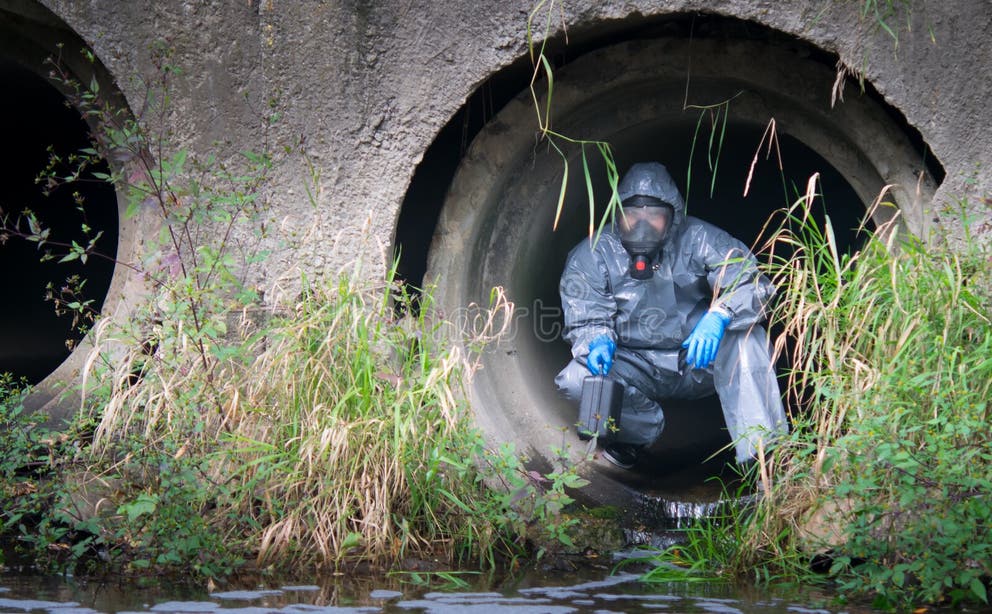 Scientist in Protective Clothing, with a Suitcase Goes into the Drain ...