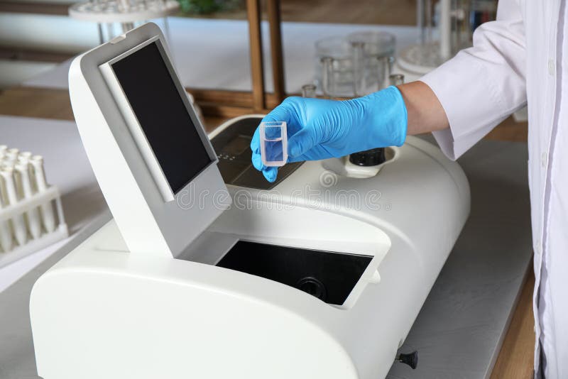 Scientist Putting Sample Compartment with Liquid in Spectrophotometer ...