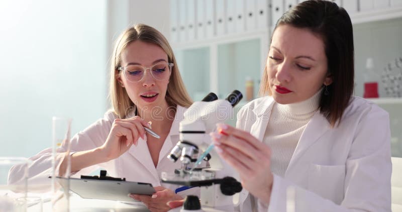 Scientist with Student Laboratory Assistant Drops Blue Liquid from ...
