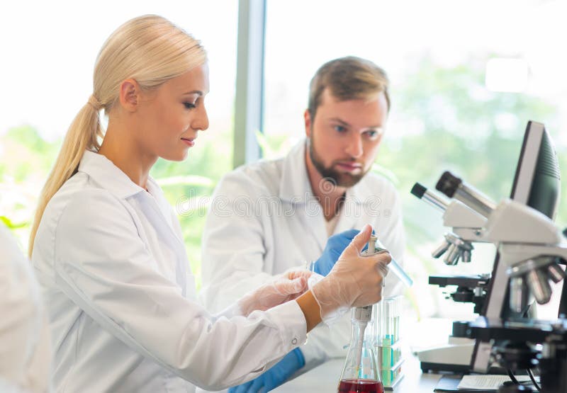 Scientist and Students Working in Lab. Doctor Teaching Interns To Make ...