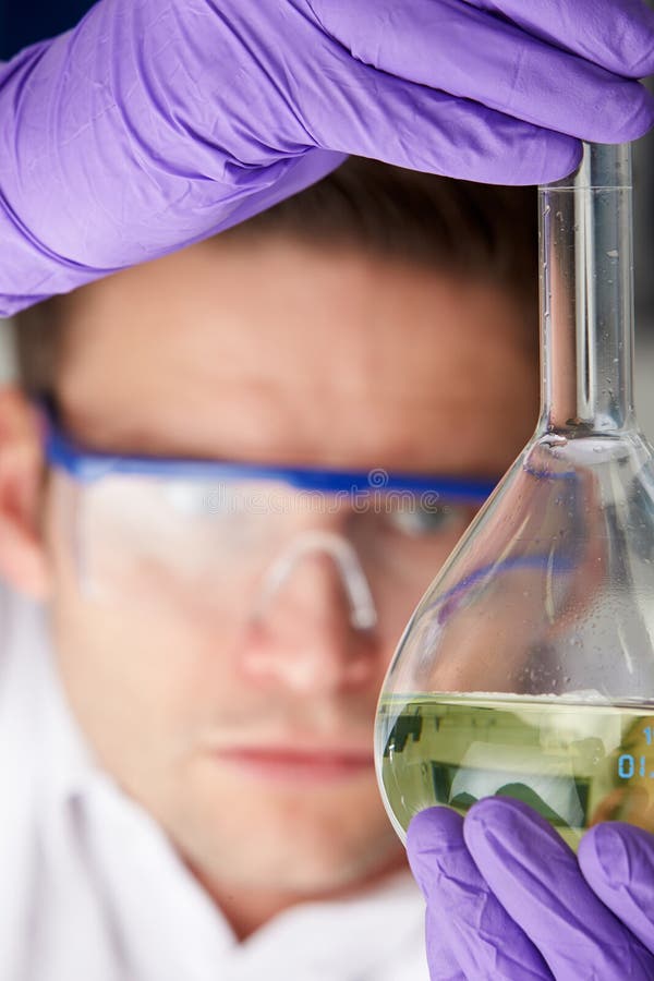 Scientist Pouring Liquid from Test Tube into Flask Stock Image - Image ...