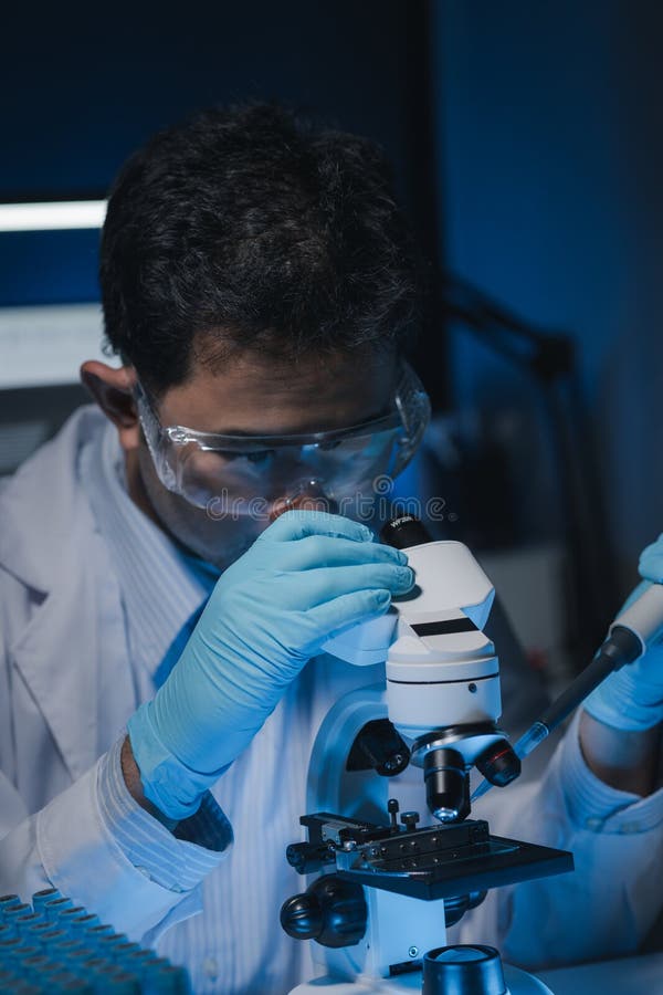A Scientist is Studying Samples Using a Microscope To Study and Develop ...