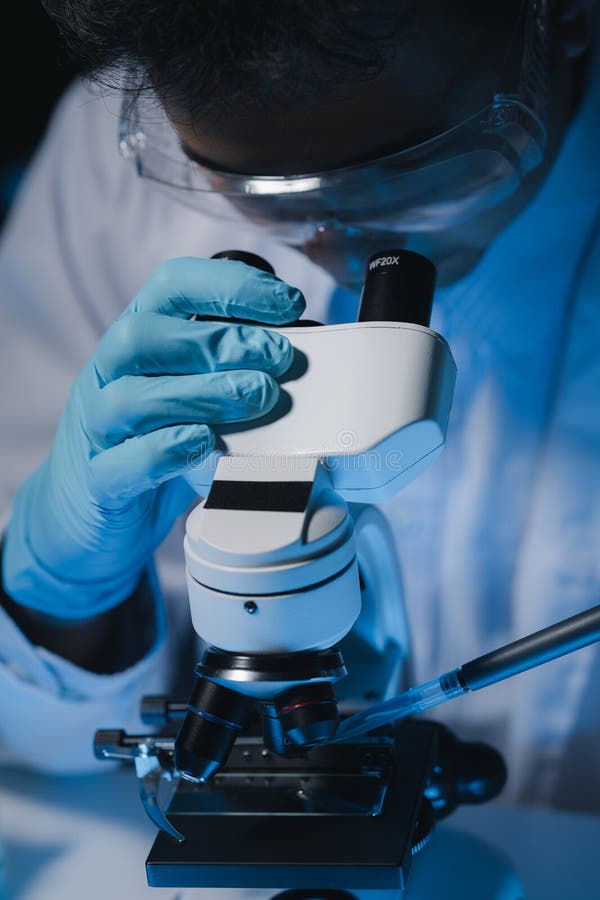 A Scientist is Studying Samples Using a Microscope To Study and Develop ...