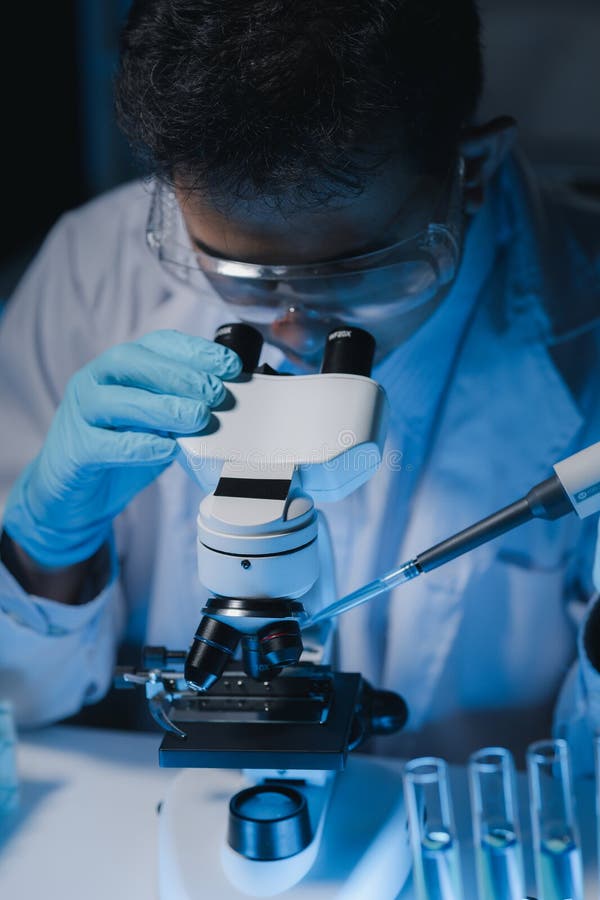 A Scientist is Studying Samples Using a Microscope To Study and Develop ...
