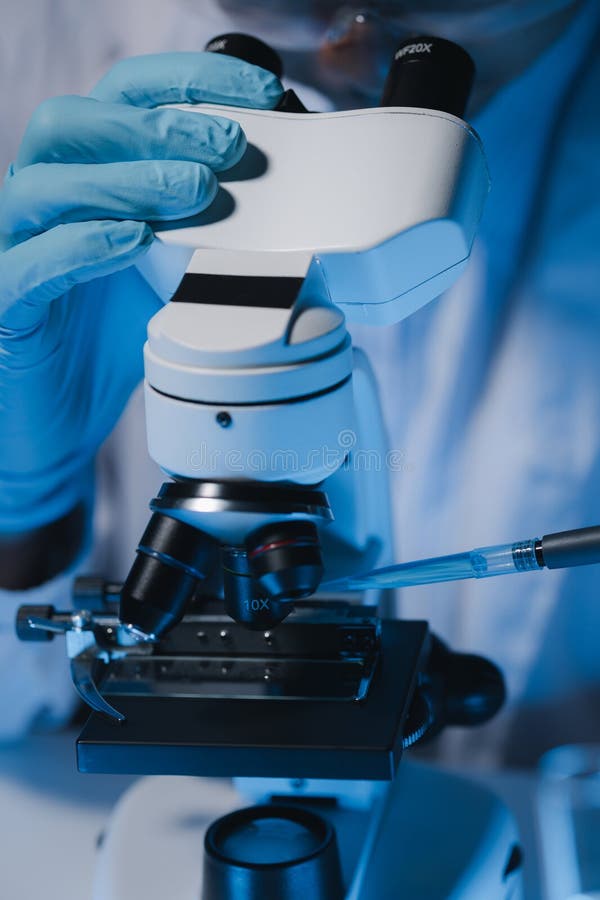 A Scientist is Studying Samples Using a Microscope To Study and Develop ...