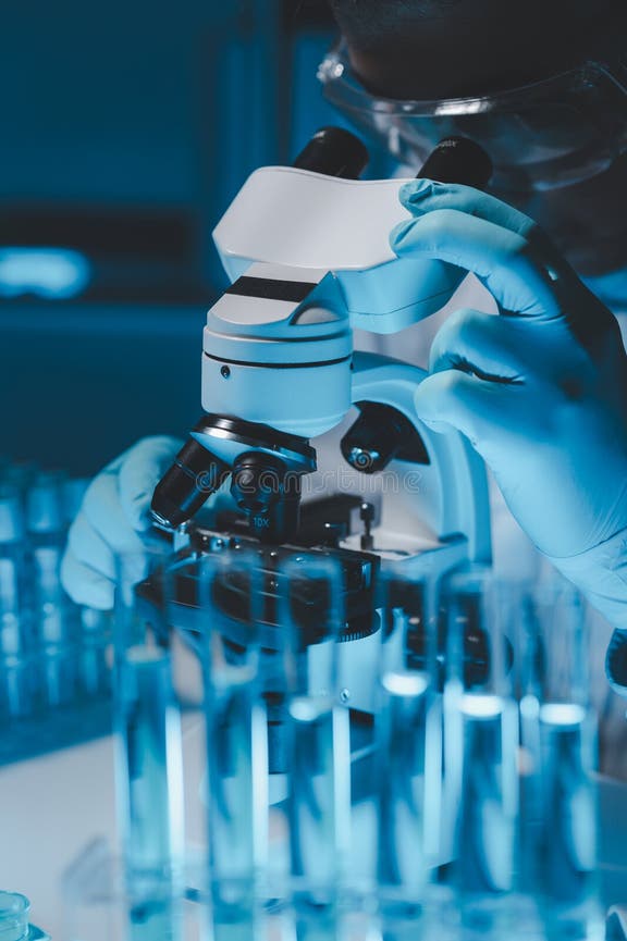 A Scientist is Studying Samples Using a Microscope To Study and Develop ...