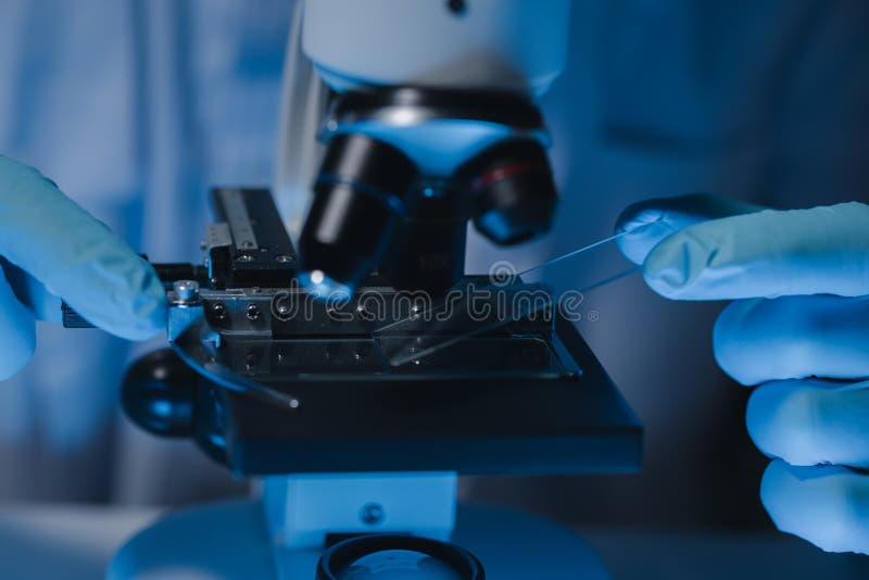 A Scientist is Studying Samples Using a Microscope To Study and Develop ...