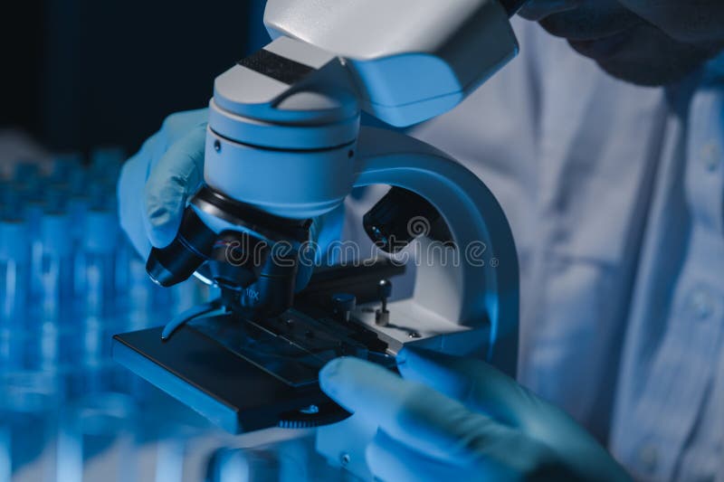 A Scientist is Studying Samples Using a Microscope To Study and Develop ...