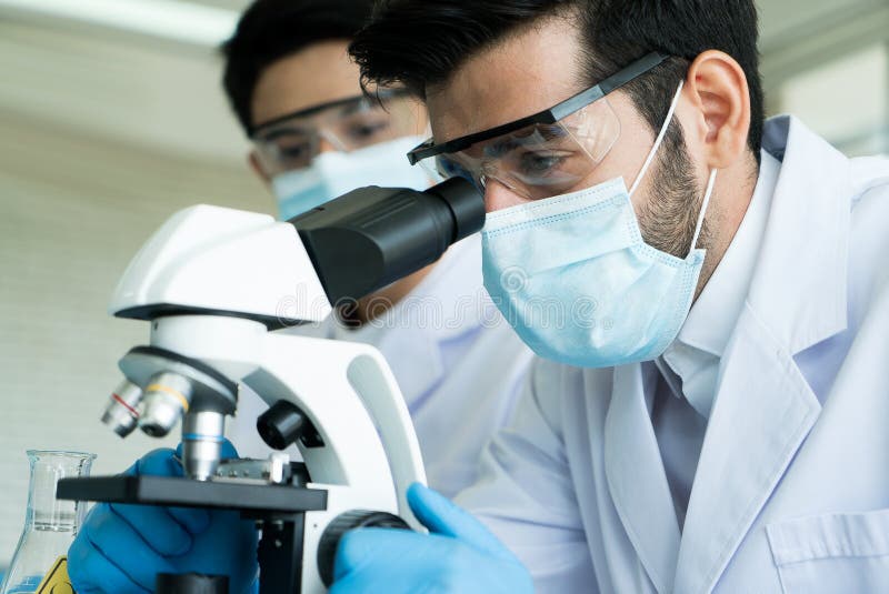 Scientist Team Providing Protection Using Microscope . Stock Photo ...
