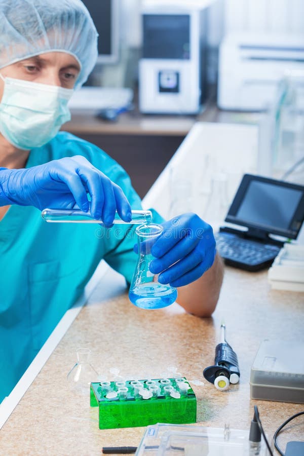 Scientist with Test Tubes and Flasks Conducting an Experiment in a ...