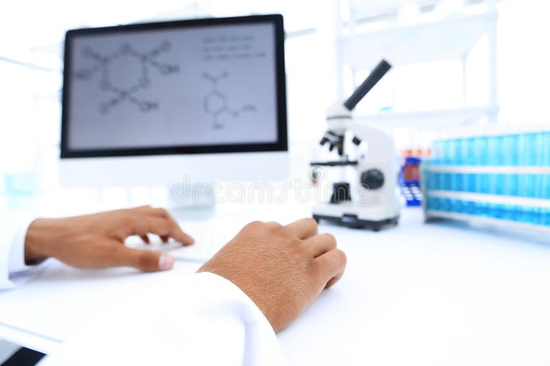 A Scientist Uses a Computer and a Microscope Stock Photo - Image of ...