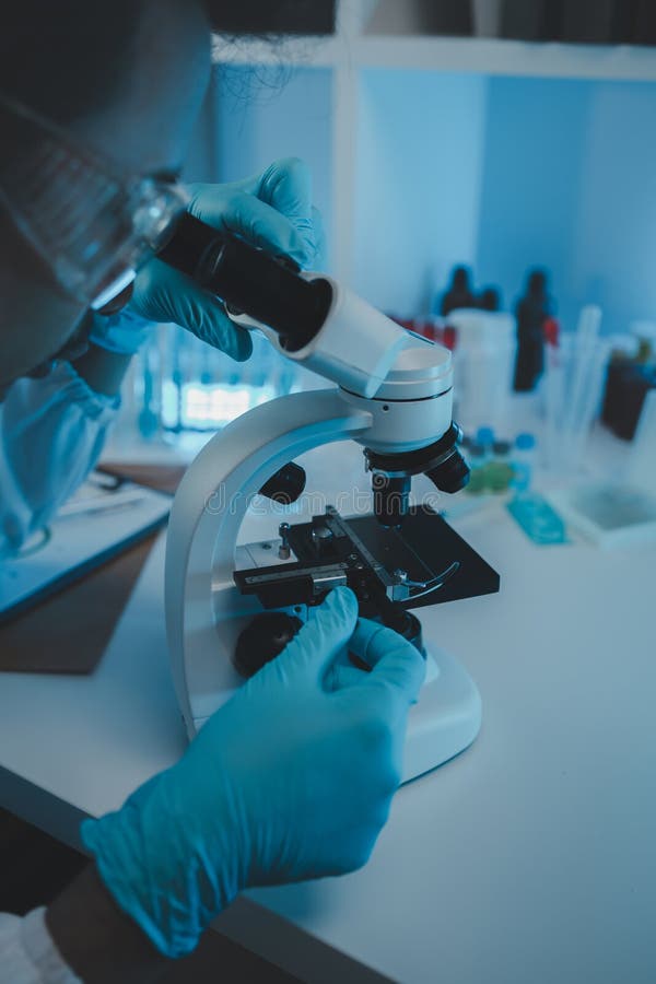 A Scientist Uses a Microscope To Look for Contaminants in a Test Sample ...