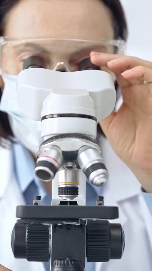 Scientist Using Microscope in Laboratory. Close Up on a Woman Face with ...