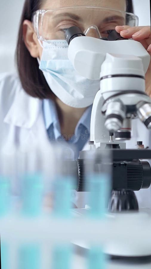Scientist Using Microscope in Laboratory. Close Up on a Woman Face with ...