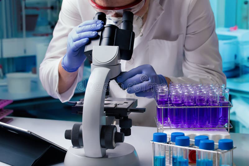 Scientist Using Microscope in Laboratory with Test Tubes Stock Photo ...