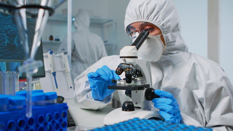 Scientist Wearing Ppe Suit Looking at Samples Under Microscope Stock ...