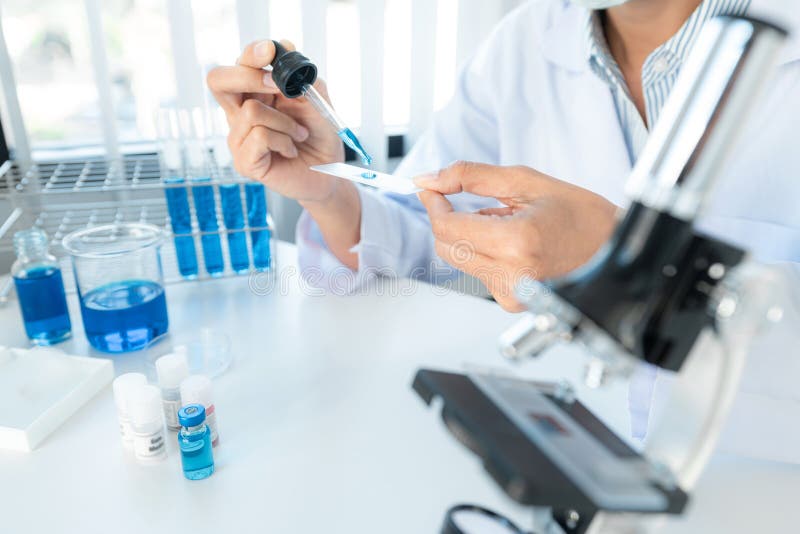 Scientist Woman Holding Dropper To Dropping Solution Sample on the ...