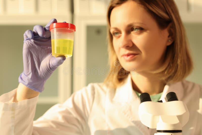 A Woman Holds a Sample with Yellow Liquid, a Close-up Stock Photo ...