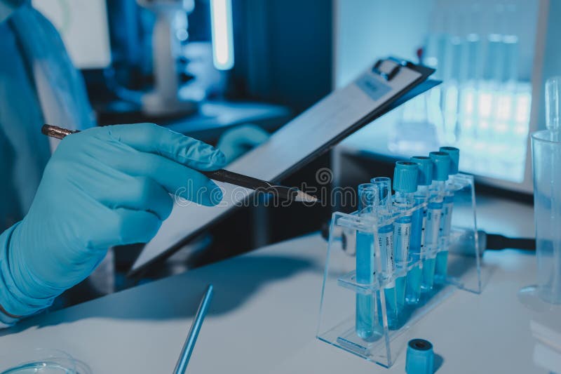 A Scientist is Working in Laboratory and Taking Note of Experiment ...