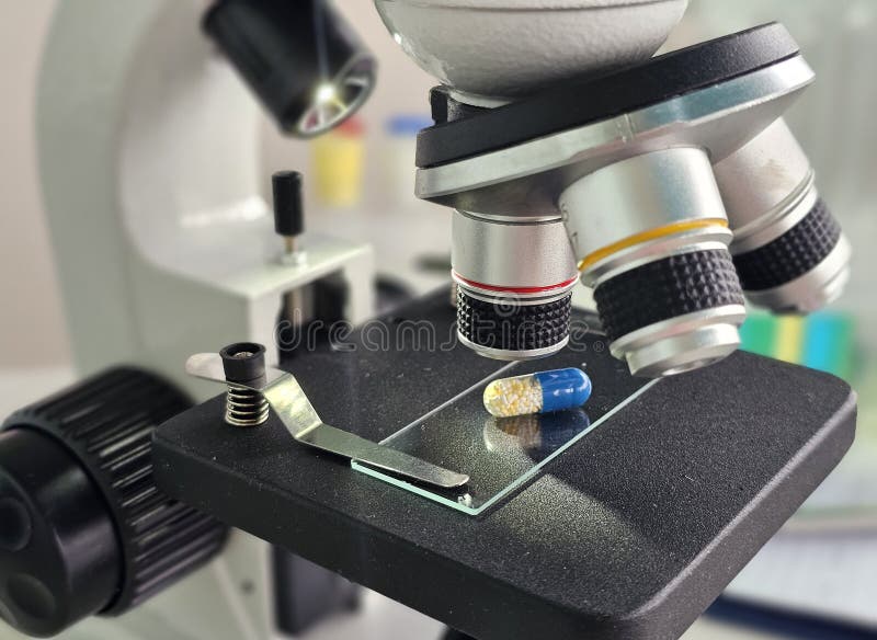 Scientists Analyze a Capsule Using a Microscope in a Laboratory Stock ...