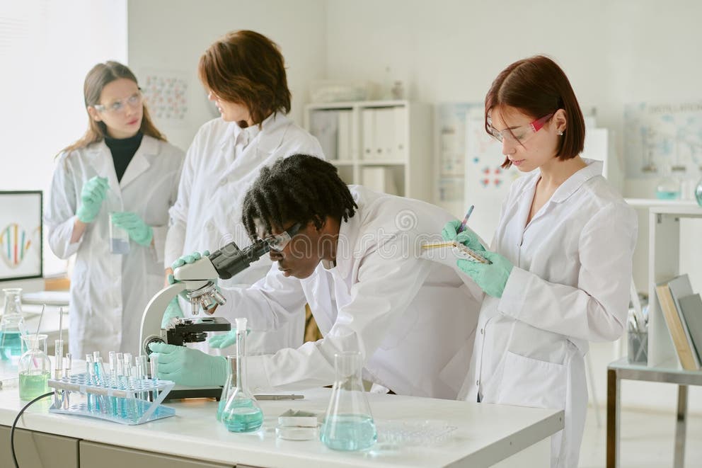 Scientists Collaborating in Laboratory Using Microscope Stock Image ...