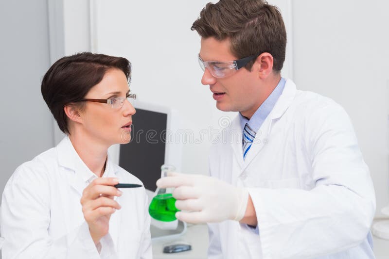 Scientists Examining Attentively Beaker with Green Fluid Stock Image ...