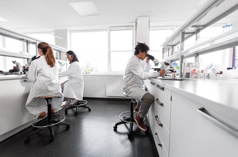 Scientists with Microscopes Working in Laboratory Stock Image - Image ...