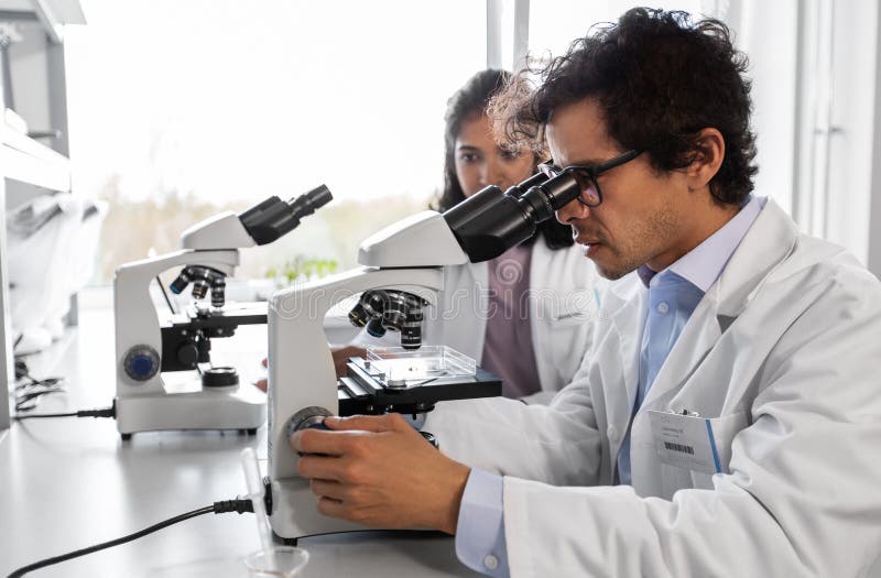 Scientists with Microscopes Working in Laboratory Stock Photo - Image ...