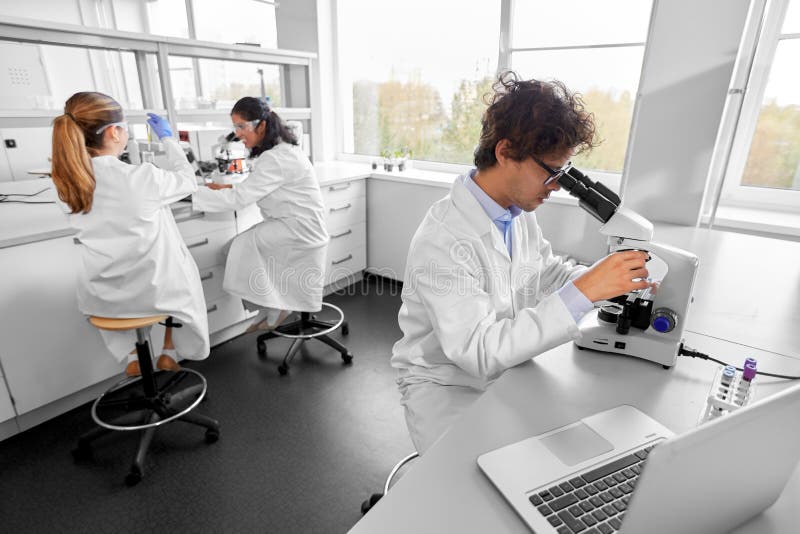 Scientists with Microscopes Working in Laboratory Stock Image - Image ...
