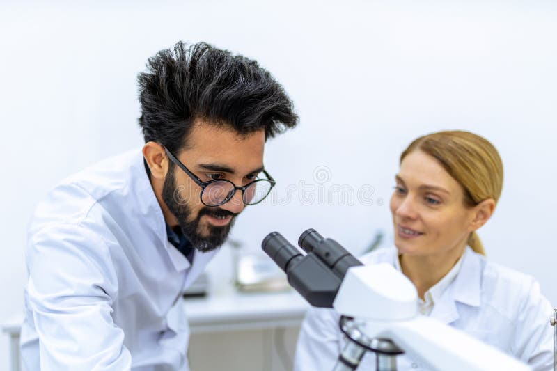 Scientists Using Microscope, Doing Sample Analysis, Talking, Team of ...