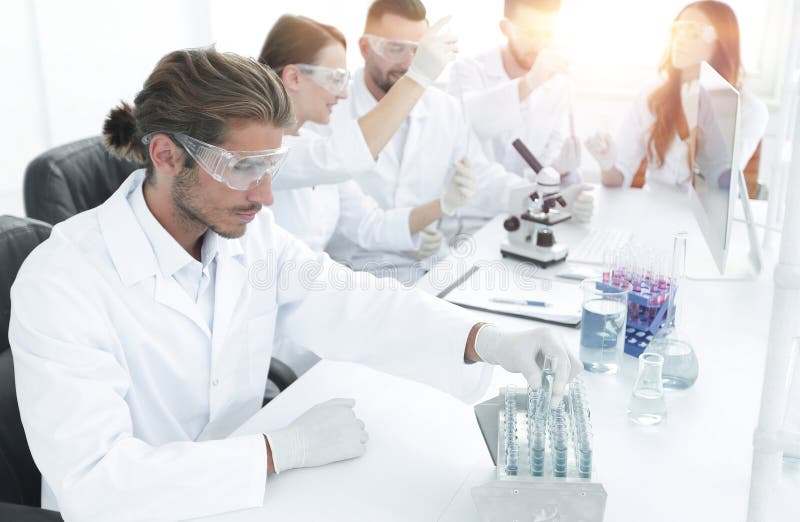 Scientists Working with a Microscope and Make Notes in the Workp Stock ...