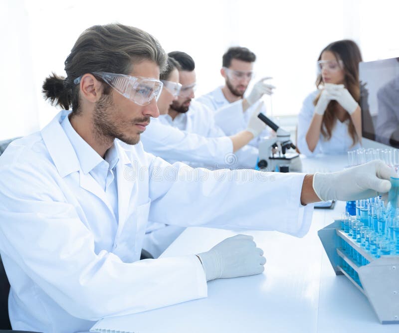 Scientists Working with a Microscope and Make Notes in the Workplace ...