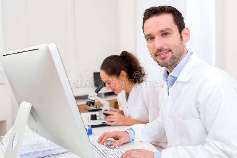 Scientists Working Together in a Laboratory Stock Photo - Image of note ...