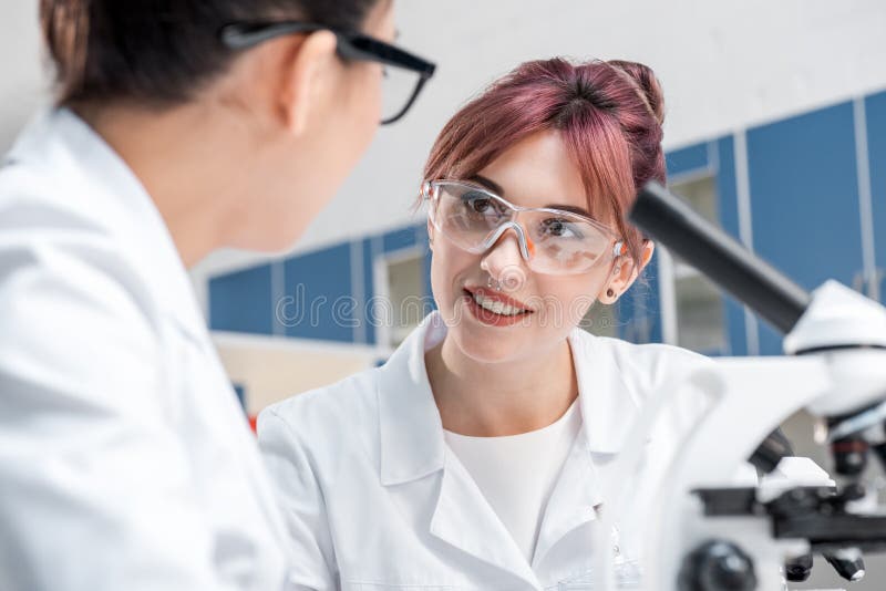 Scientists Working Together with Microscopes in Chemical Lab Stock ...