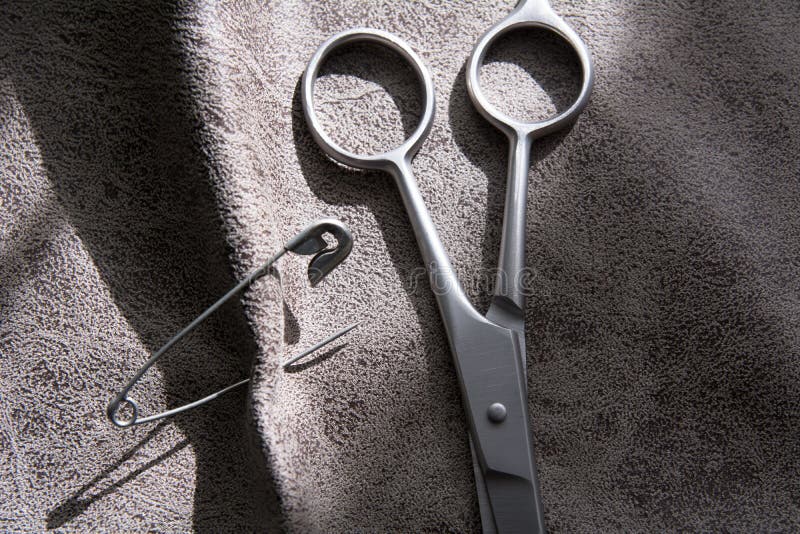 Scissors and a Pin on a Gray Fabric with a Rough Surface Stock Image ...