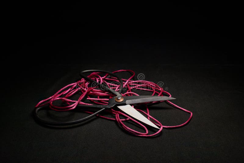 Scissors and Pink Rope on Dark Background in Dramatic Lighting Stock ...