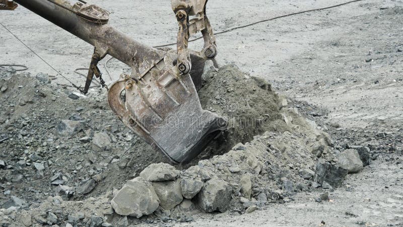 Scoop of Excavator is Digging Hole. Excavator Digs Pit in Ground for ...