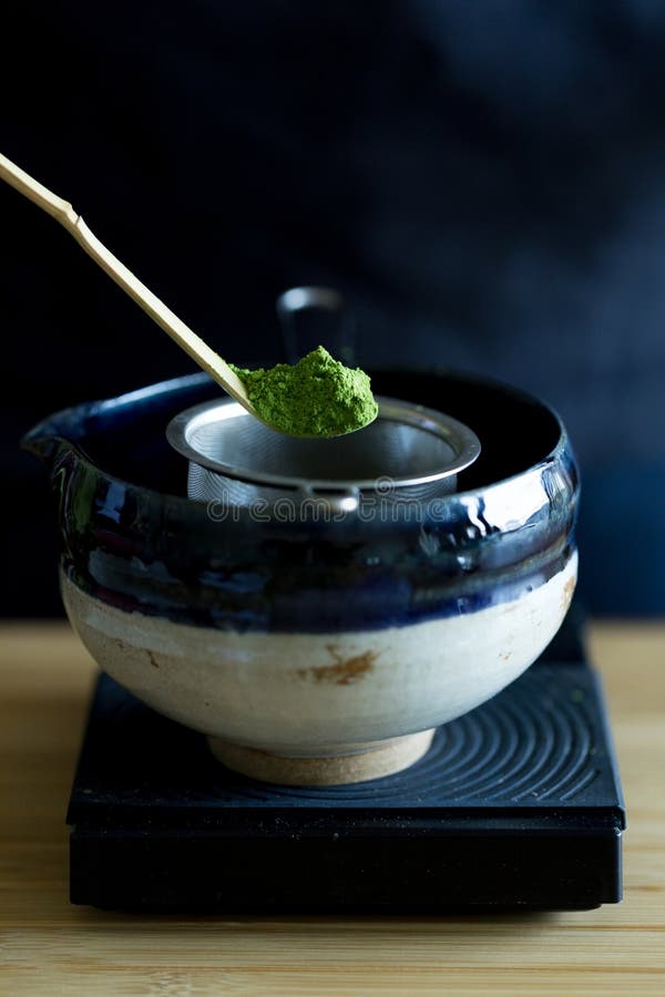 A Scoop of Matcha Powder in Bamboo Spoon Over Ceramic Bowl Stock Photo ...
