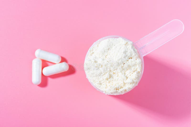 Scoop with Protein Powder and Capsules on Pink Background Top View ...