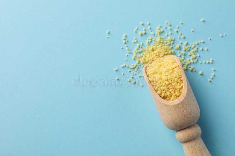 Scoop with Raw Couscous on Blue Background, Space for Text Stock Photo ...