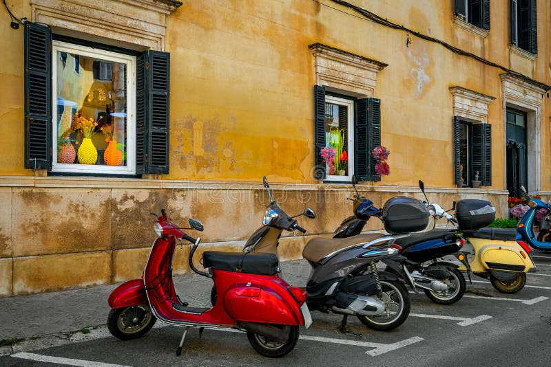 Scooters Parked Along the Side of the Road in Front of a Building with ...