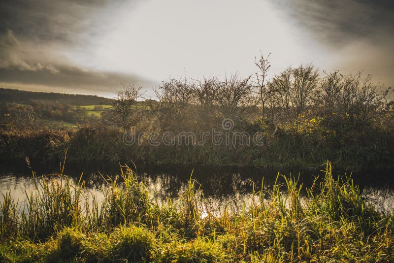 Scottish Dramatic Sky Landscape with River Grass and Powerful Sun Stock ...