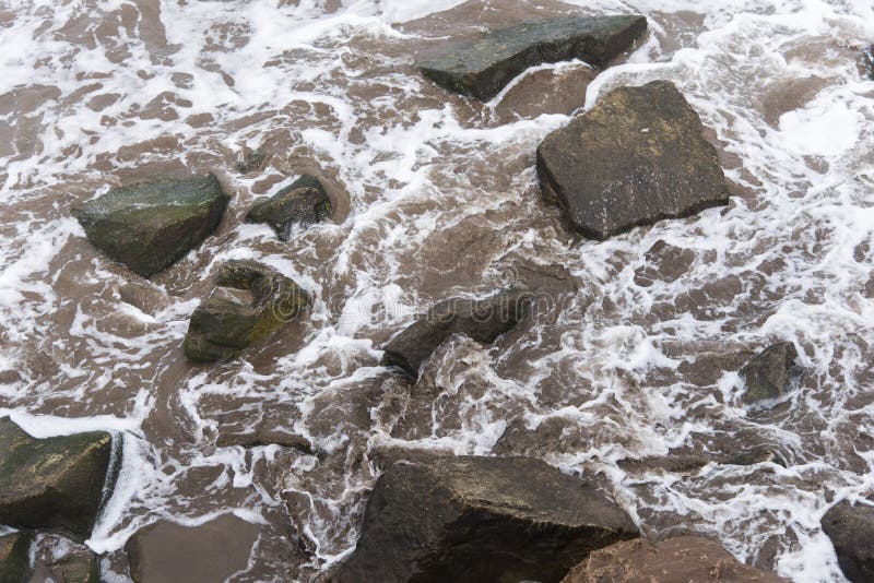 Scrambled Seawater, with White Foam, between the Rocks of the Shore ...