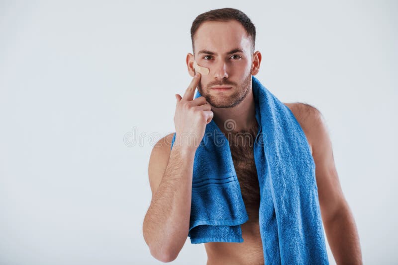 Scratch on Face. Man with Blue Towel Stands Against White Background in ...