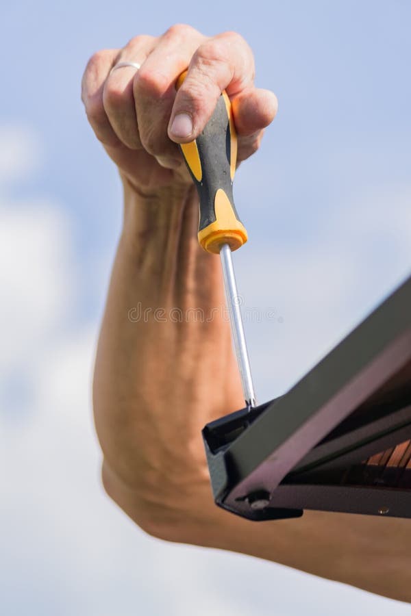 Screwdriver in Males Hands. Worker with a Hand Tool Assembling Metal ...