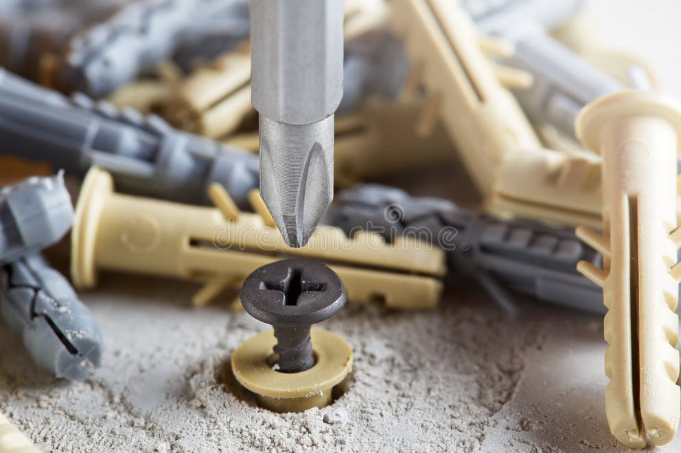Screwdriver and Dowel in a Concrete Wall Background Stock Photo - Image ...