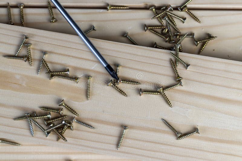 Screwdriver and Screws for Fixing Wood Lying on a Board, a Stock Image ...